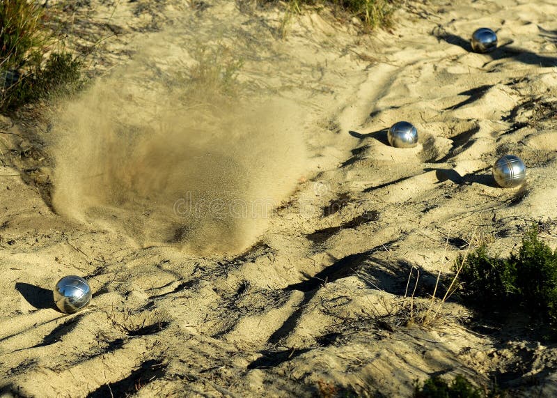 A Boules Metal Ball Disappearing in a Sand Spray Stock Photo - Image of ...