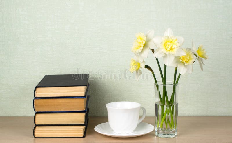 A Bouquet of Light Daffodils in a Glass Vase, a Stack of Thick Books ...
