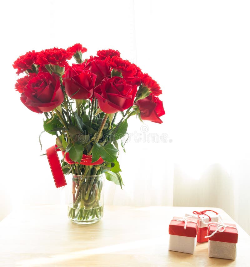 Bouquet of Red Roses and Red Ribbon with Present on Wood Table Stock ...