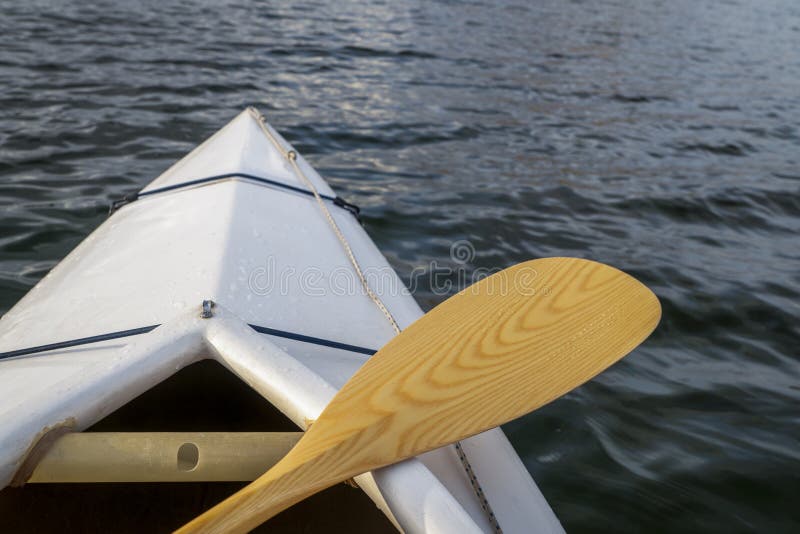 Bow of a Decked Expedition Canoe with Wooden Paddle on a Lake Stock ...