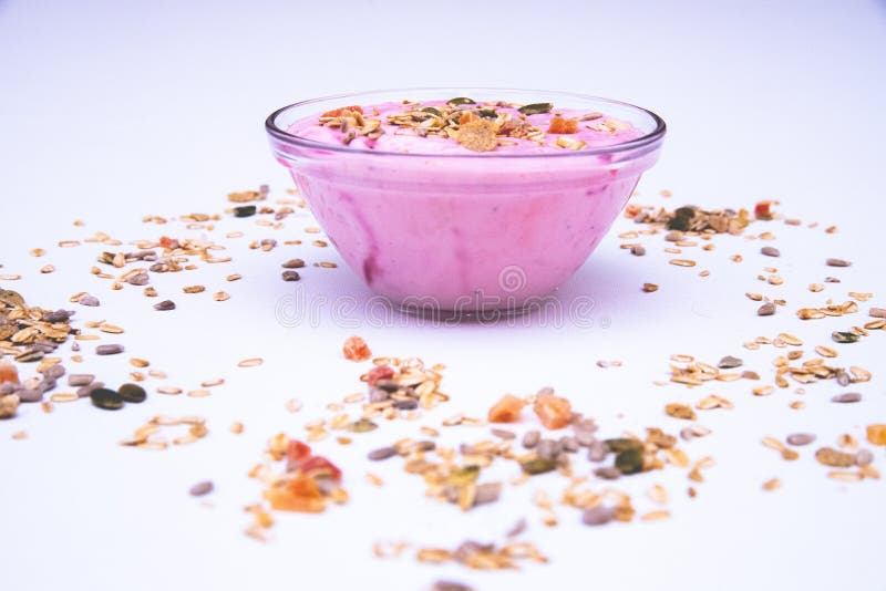 Bowl of Berry Yogurt with Grains and Fruit Chunks on it on a White ...