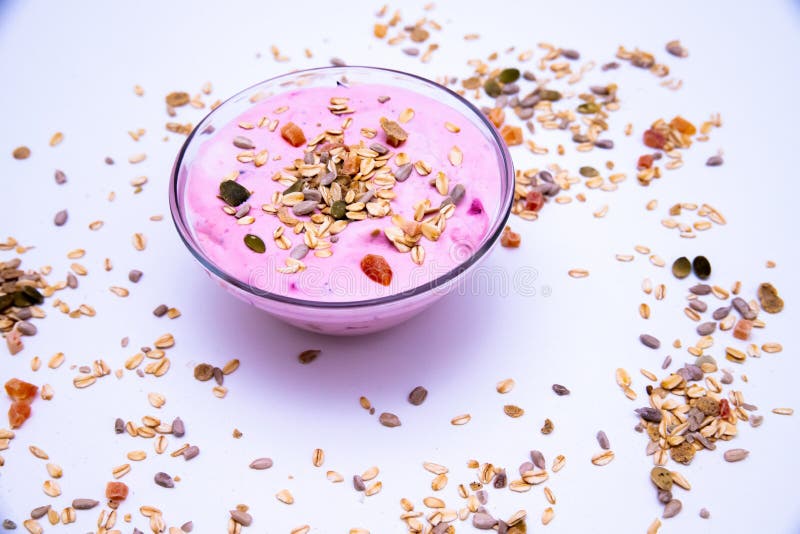 Bowl of Berry Yogurt with Grains and Fruit Chunks on it on a White ...