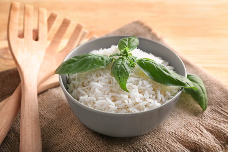 Bowl with Boiled White Rice and Fresh Basil Leaves on Wooden Table ...