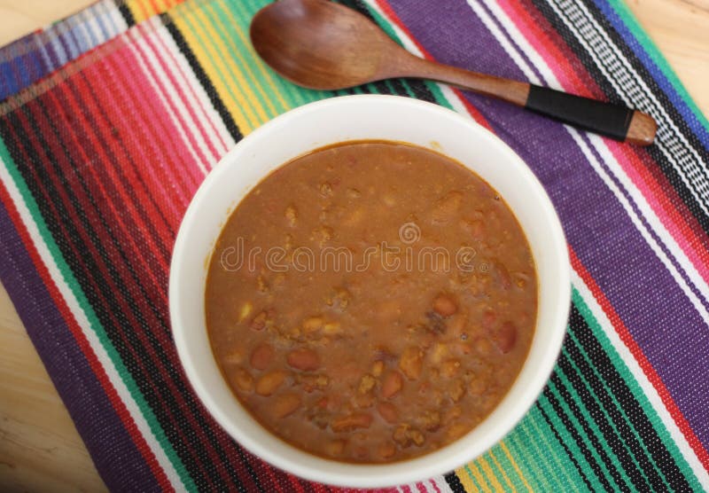 Bowl of Chili with Pinto Beans on Table with Peppers and Dry Beans in ...