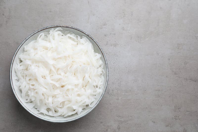 Bowl with Cooked Rice Noodles on Light Grey Table, Top View. Space for ...