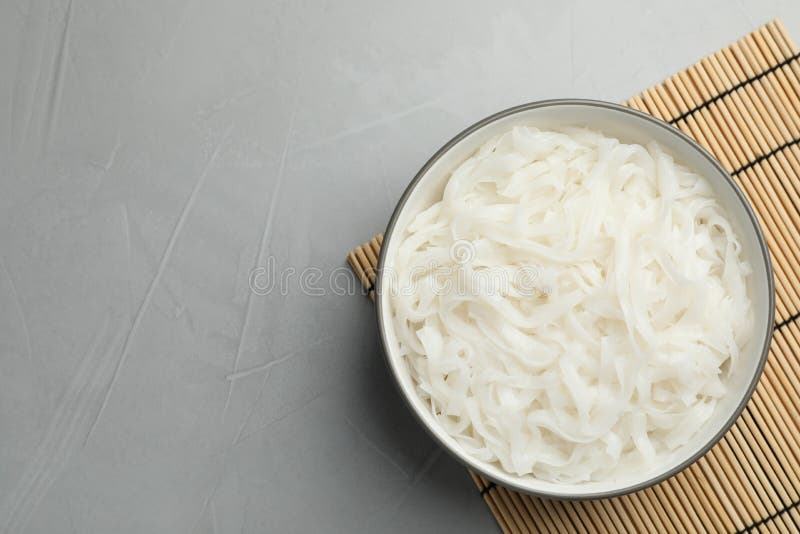 Bowl with Cooked Rice Noodles and Straw Mat on Light Grey Table, Top ...