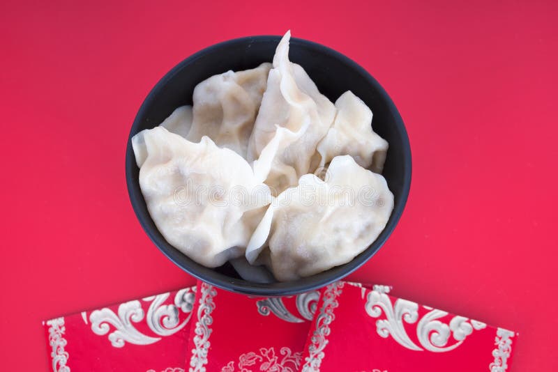A Bowl of Dumplings and Red Packets on a Red Background Stock Image ...