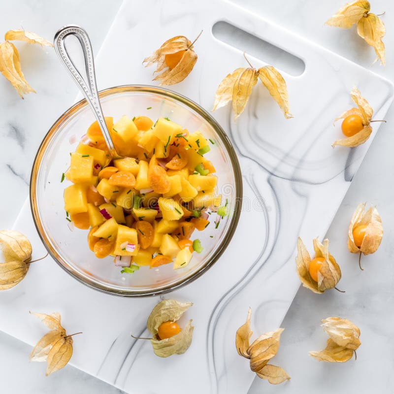 A Bowl of Golden Berry and Mango Salsa Surrounded by Whole Golden ...