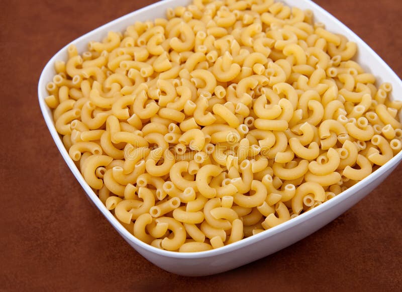Elbow macaroni over black stock image. Image of dish - 15800387