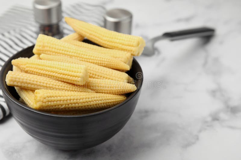 Bowl of Pickled Baby Corn on White Marble Table, Closeup. Space for ...
