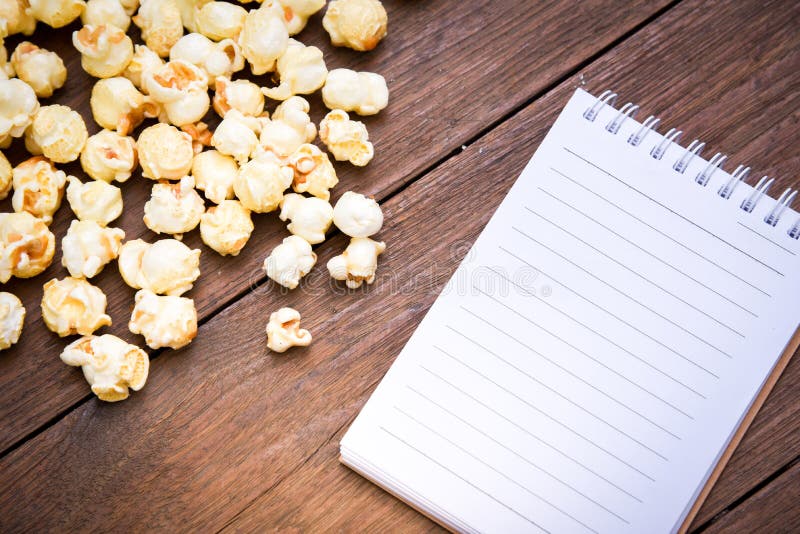 A Bowl of Popcorn and Notebook on a Wooden Table. Stock Photo - Image ...