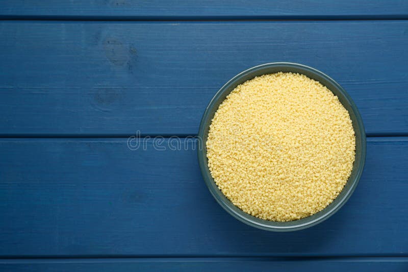 Bowl of Raw Couscous on Blue Wooden Table, Top View. Space for Text ...