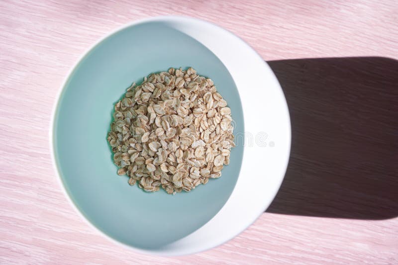 Bowl of Rolled Oats on Pink Surface Casting Shadow in Natural Light ...