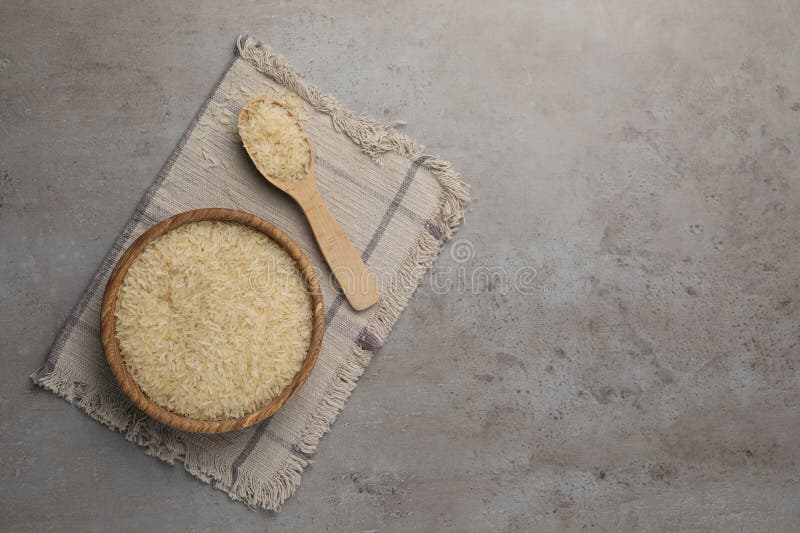 Bowl and Spoon of Raw Rice on Grey Table, Top View. Space for Text ...