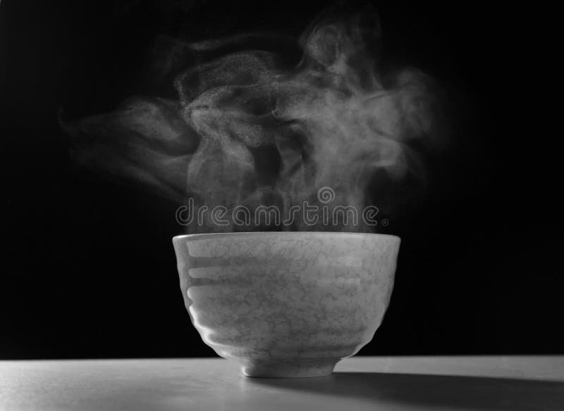 Bowl with Steam on Table Against Black Background Stock Image - Image ...