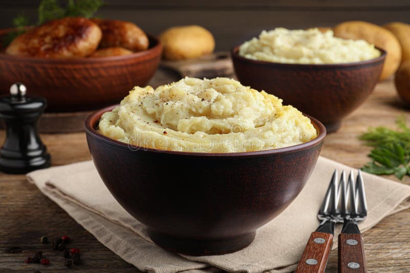 Bowl of Tasty Mashed Potatoes with Black Pepper Served on Wooden Table ...