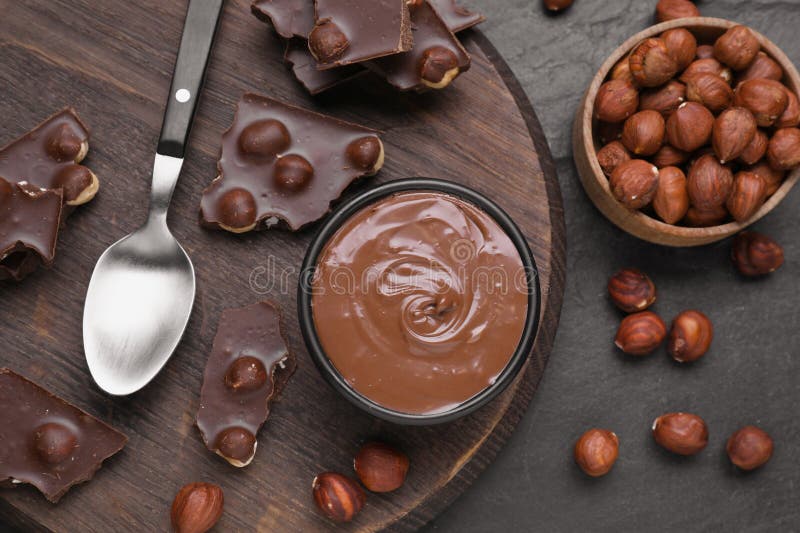 Bowl with Tasty Paste, Chocolate Pieces and Nuts on Grey Table, Flat ...
