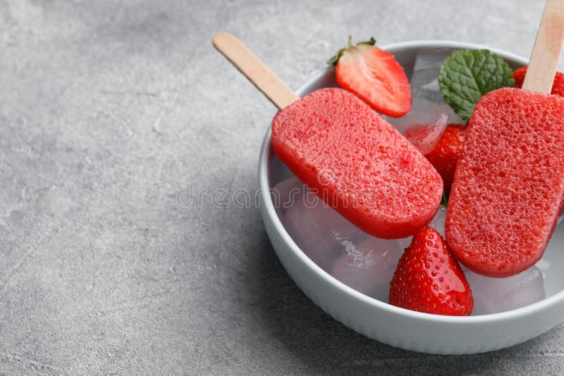 Bowl of Tasty Strawberry Ice Pops on Grey Table, Space for Text. Fruit ...