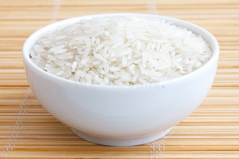 Bowl of Uncooked White Long Grain Rice on a Bamboo Mat Stock Photo ...