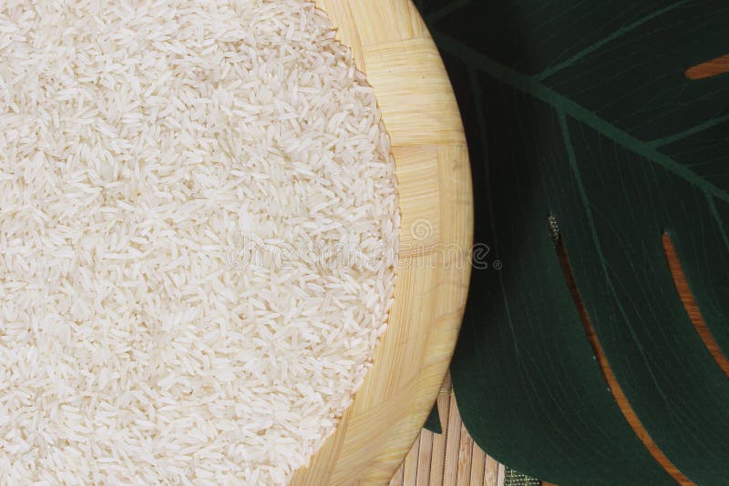 Bowl of Uncooked White Rice with Leaf and Bamboo Mat Stock Photo ...