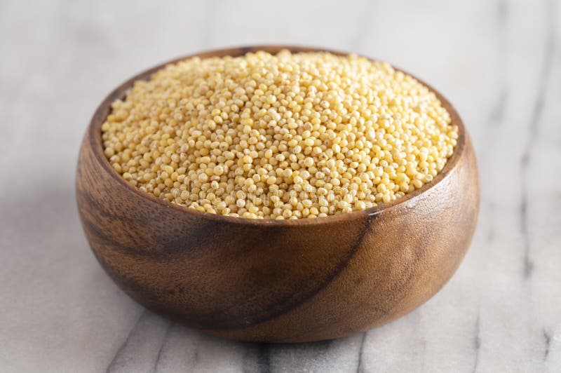 Bowl of Whole Millet in a Wood Bowl on a White Marble Counter Stock ...