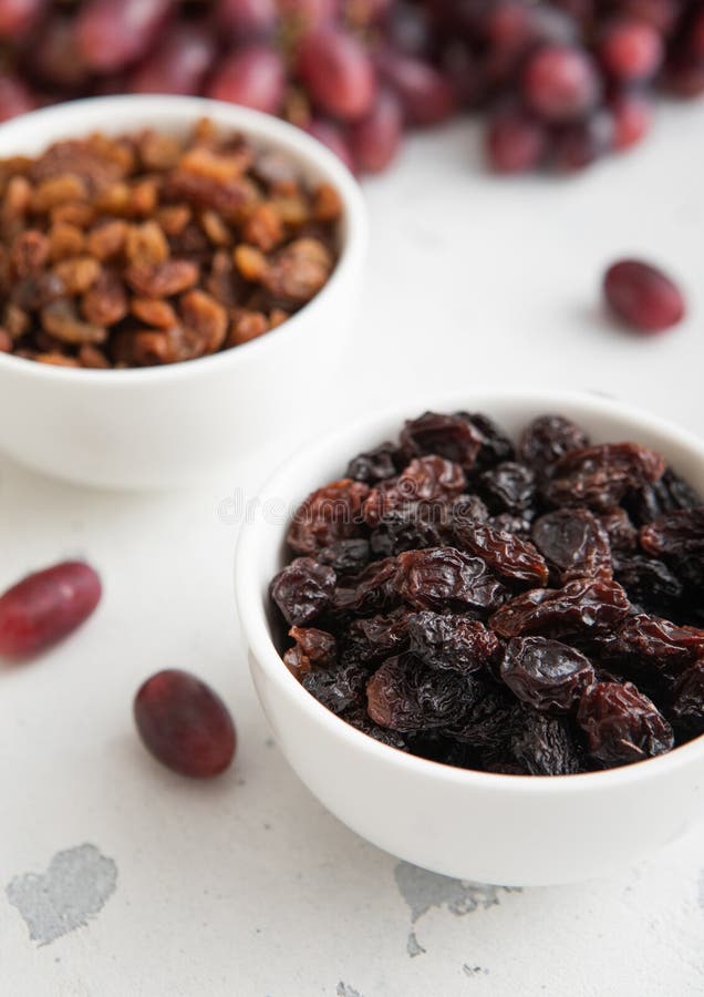 Bowls of Brown and Dark Raisins with Ripe Red Grapes on Light ...