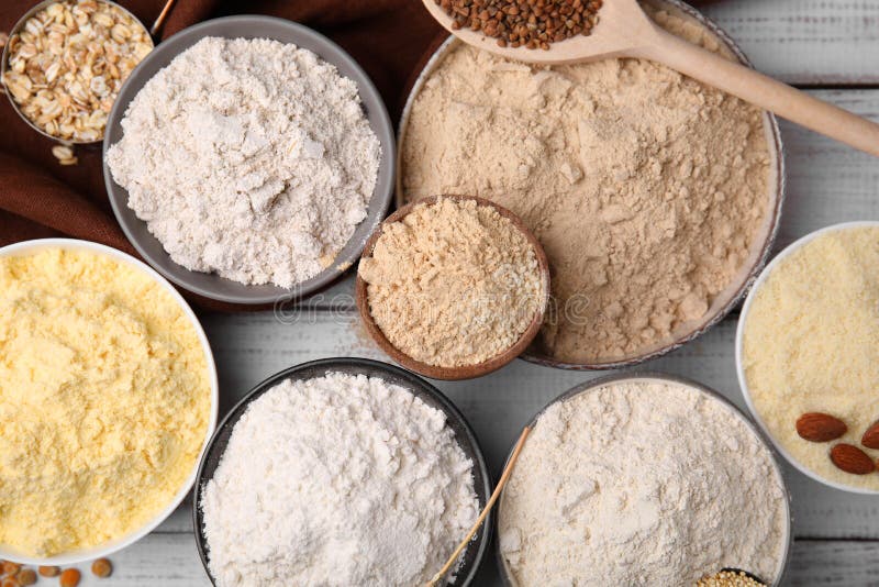 Bowls with Different Types of Flour on White Wooden Table, Flat Lay ...