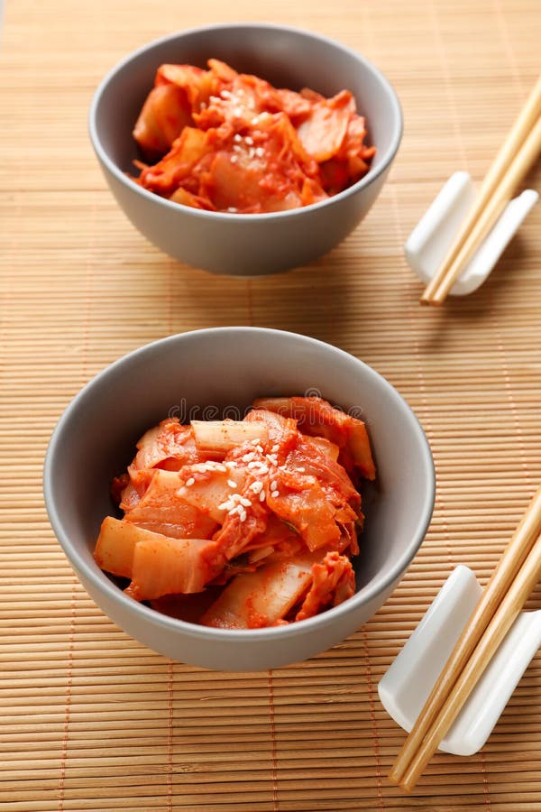 Bowls of Spicy Cabbage Kimchi and Chopsticks on Bamboo Mat Stock Image ...