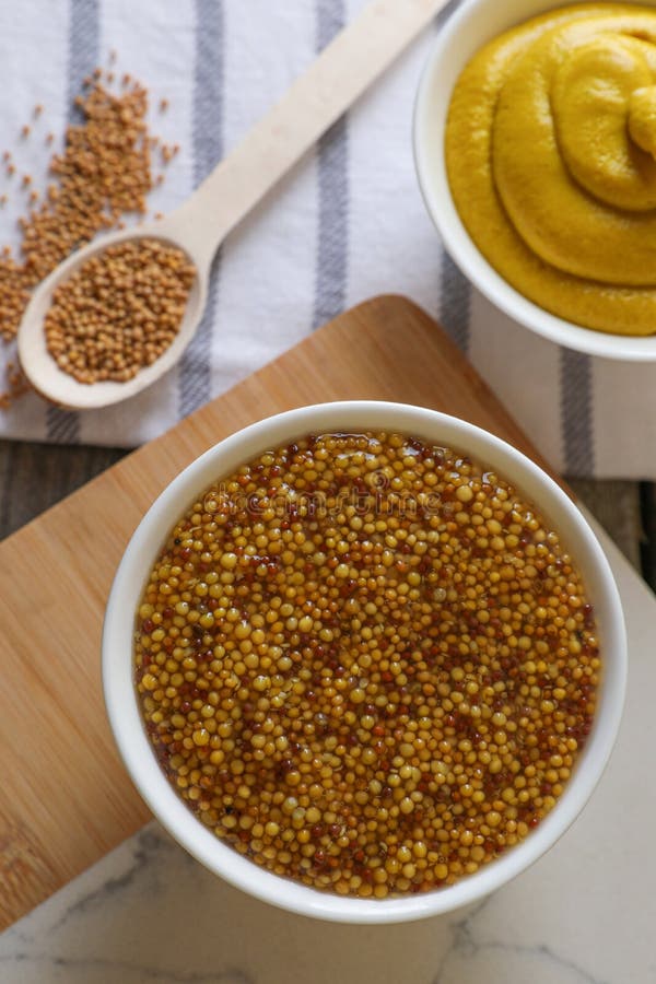 Bowls and Spoon of Whole Grain Mustard on Wooden Table, Flat Lay Stock ...