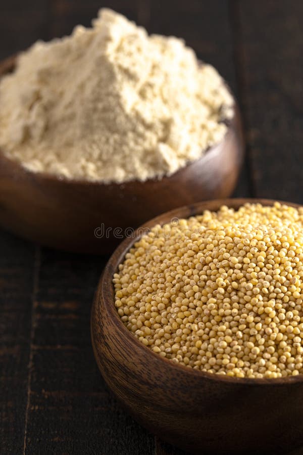 Bowls of Whole Millet and Millet Flour in Wood Bowls on a Dark Table ...