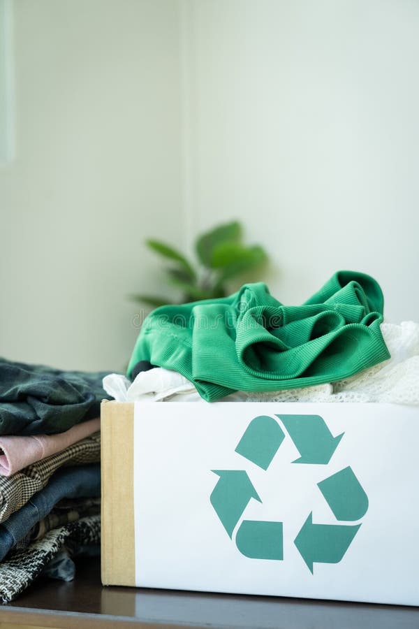 A Box of Clothes is Piled on Top of a White Box with a Green Recycling ...