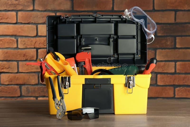 Box with Different Tools for Repair on Wooden Table Near Brick Wall ...