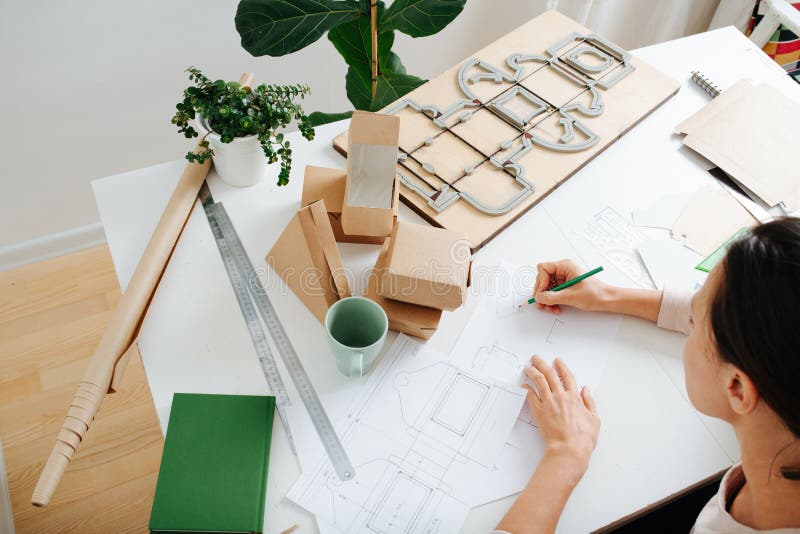 Box Maker Working Behind a Table, Drawing Scematics, Tools Scattered ...