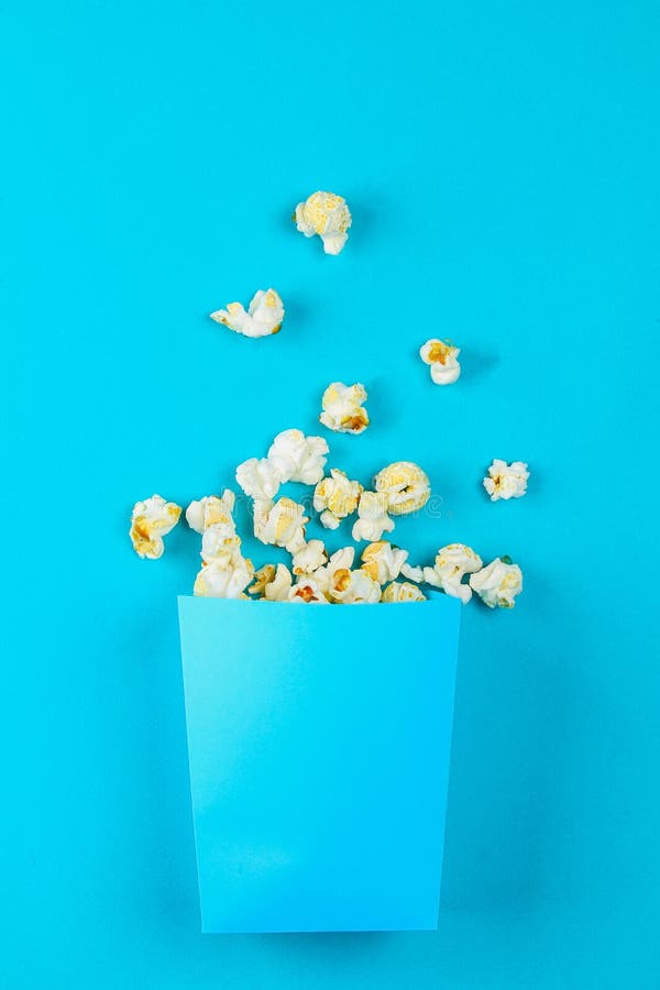 Box Of Popcorn Spilled On Blue Background. Stock Photo - Image of ...
