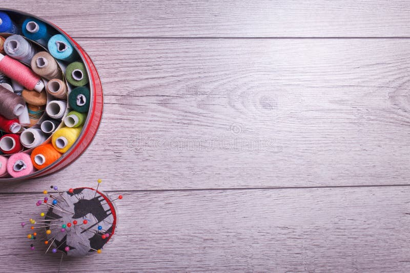 Box with Threads for Sewing and Needles on a Wooden Background Stock ...