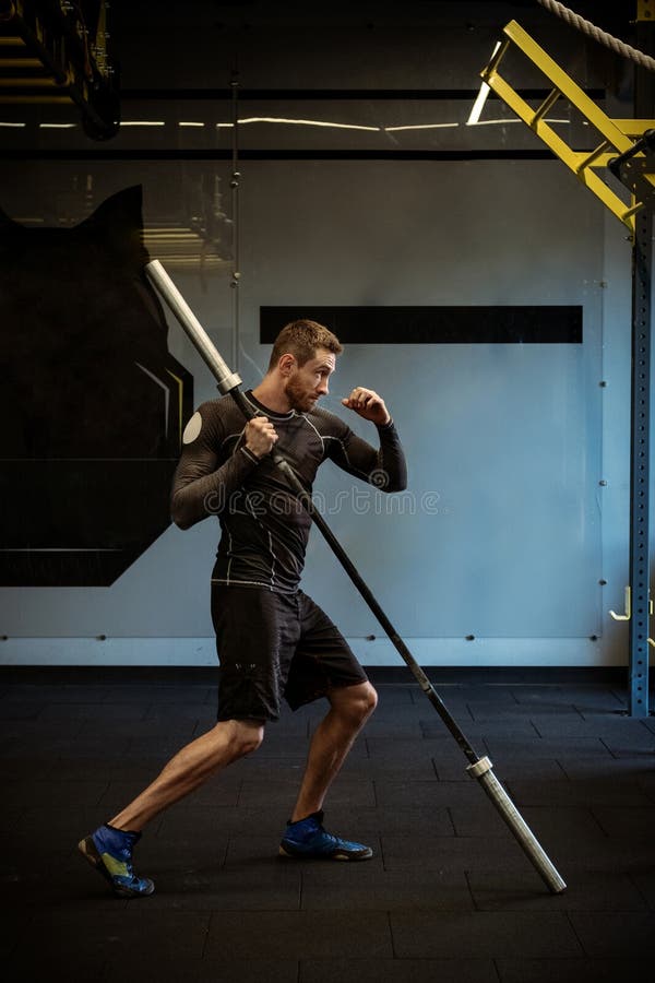 Boxer Practicing Punches with Barbell for Explosive Strength at Gym ...