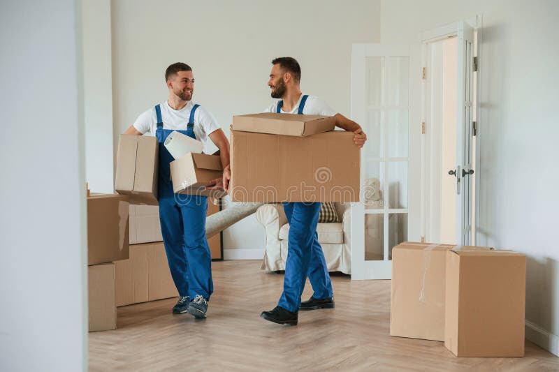 Boxes in Hands. Two Moving Service Employees in a Room Stock Image ...