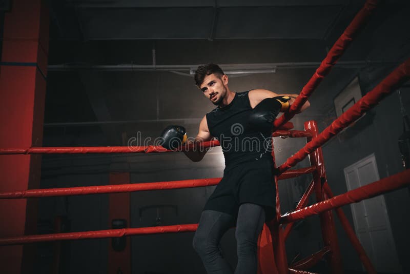 In a Boxing Ring Athletic Man Have a Break Time after a Boxing Workout ...