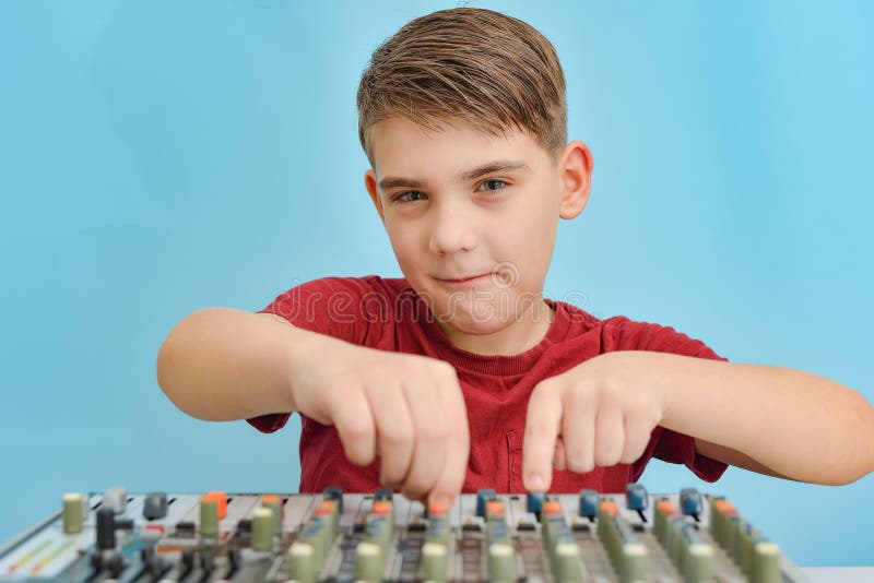 A Boy Adjusts the Equalizer of a Mixing Console in a Music Studio Stock ...