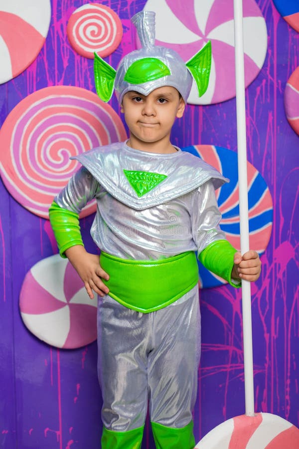 A Boy in an Alien Costume Holds a Big Candy in His Hands Against the ...