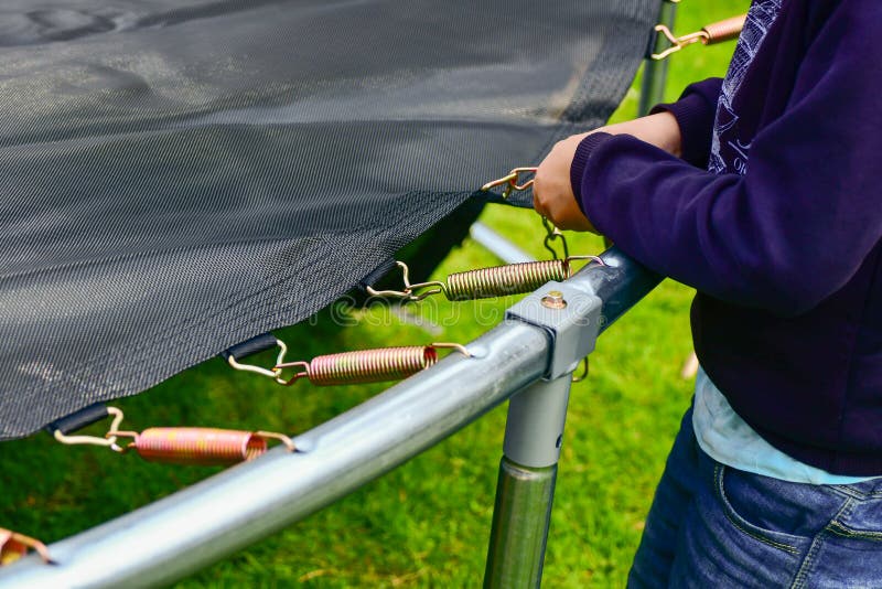 The Boy Assembles a New Trampoline and Stretches the Springs To Jump ...