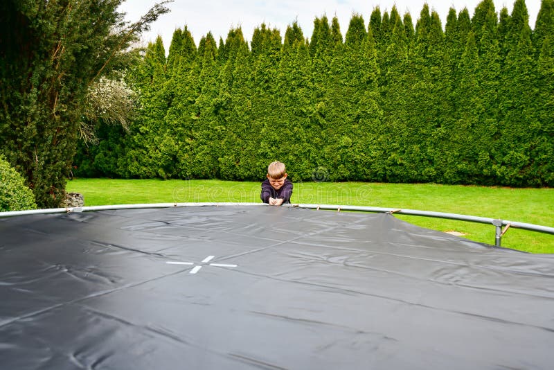 The Boy Assembles a New Trampoline and Stretches the Springs To Jump ...