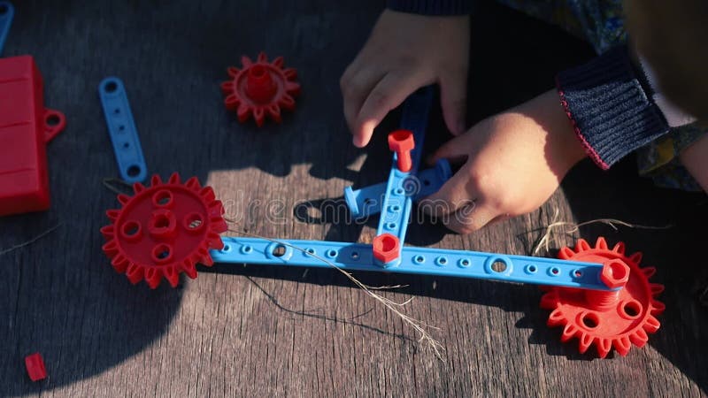 A Boy Assembles a Plastic Toy Car Set on the Ground. Stock Footage ...