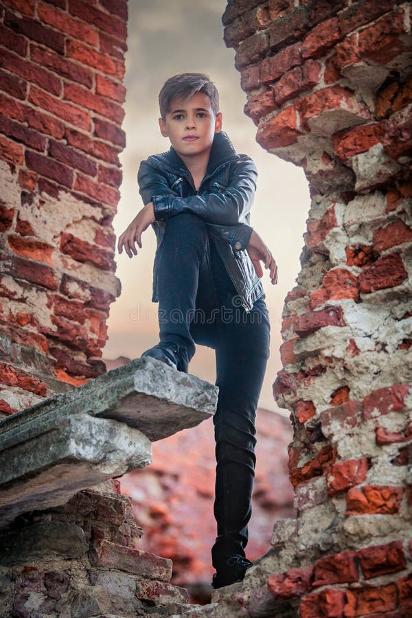 Boy of Athletic Build in Black Leather Jacket Stands on Ruined Brick ...