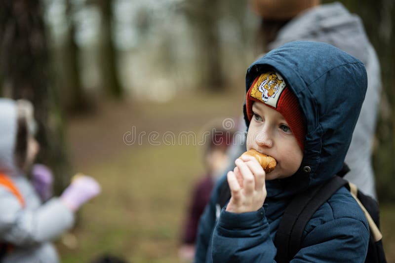 Boy with Backpack Eating Croissant in the Forest Stock Photo - Image of ...