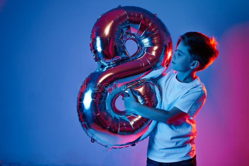A Boy with a Balloon in the Form of an Eight in Neon Light. Stock Image ... A Boy with a Balloon in the Form of an Eight in Neon Light. Stock Image ...