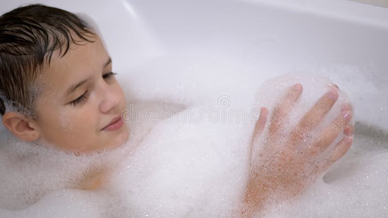 Boy Bathes in Bathroom with Foam, Plays with Bubbles of Soapy Foam ... Boy Bathes in Bathroom with Foam, Plays with Bubbles of Soapy Foam ...