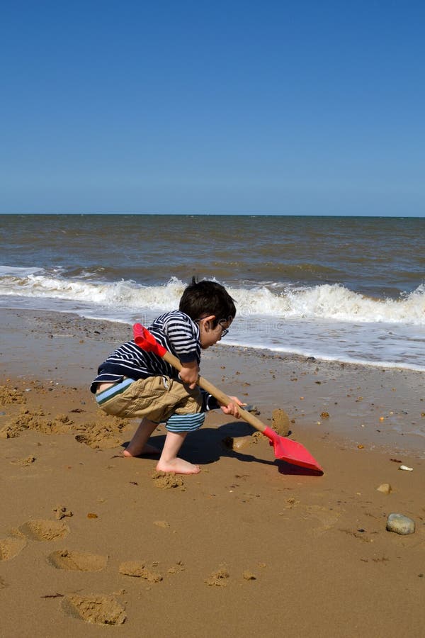 Boy on beach stock image. Image of british, digging, hole - 82247265