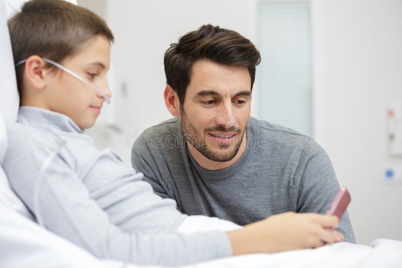 Father with Son in Hospital Waiting Room Looking at Tablet Stock Photo ...