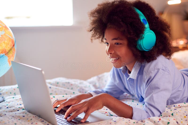 Boy in Bedroom at Night Lying on Bed Using with Laptop with Illuminated ...